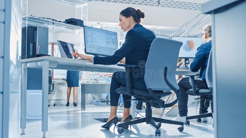 Back View of Team of Technology Engineers Working on Desktop Computers ...