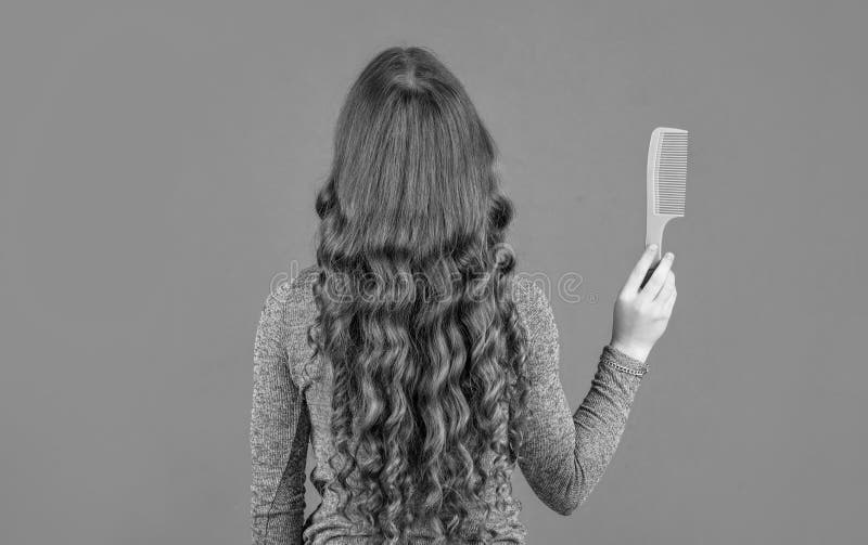 Back View Of Teen Girl With Curly Hair Hold Comb On Pink Background