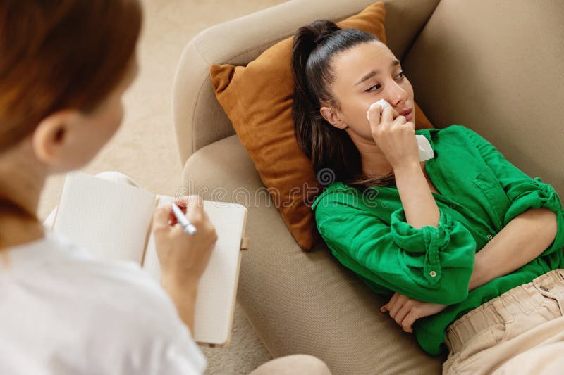 Back View of Therapist Making Notes while Female Patient is Lying on ...