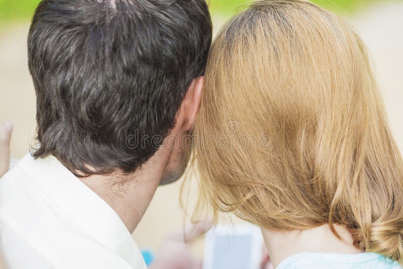 Back View of Two Young Lovers Together Outdoors Reading E-Book. Stock ...