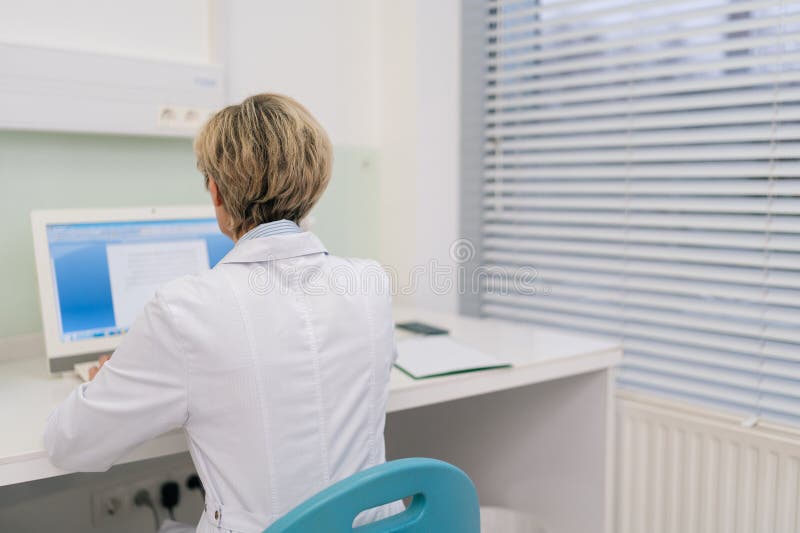 Back View of Unrecognizable Middle-aged Woman Doctor Physician in White ...