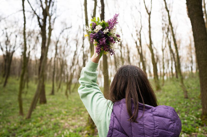 Back View of Woman with Hand Up Hold Spring Bouquet of Flowers on ...