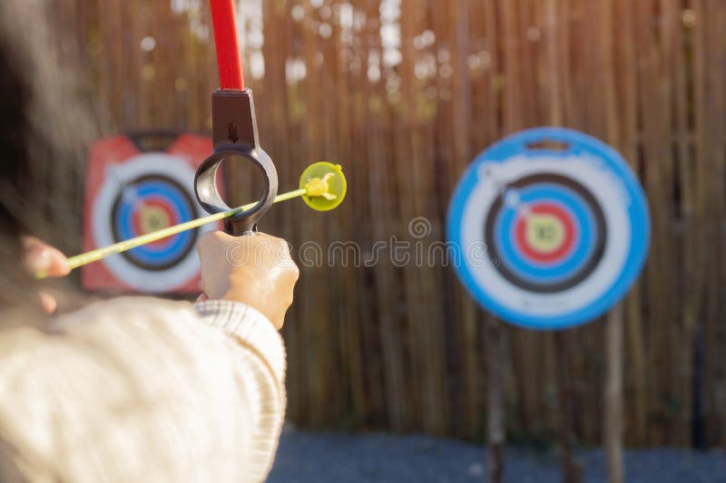 Back View of Woman Practicing or Playing Soft Archery on the Training ...