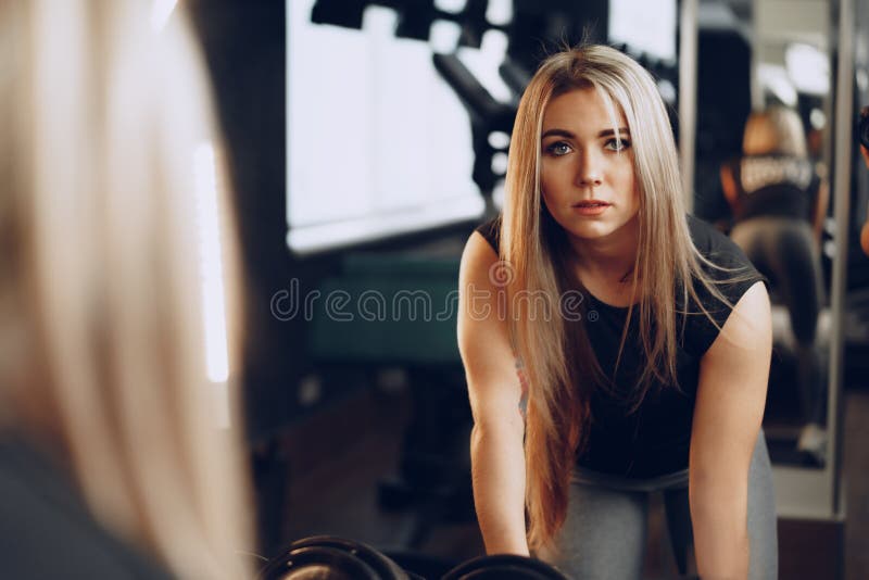 Back View of a Woman Training Her Hands with a Dumbbell in a Gym Stock ...