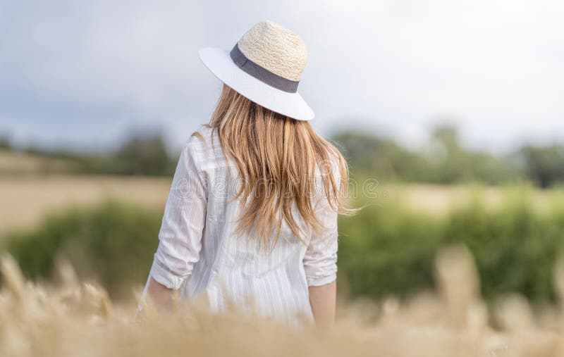 Back View of a Woman Wearing a Hat in a Field Stock Photo - Image of ...