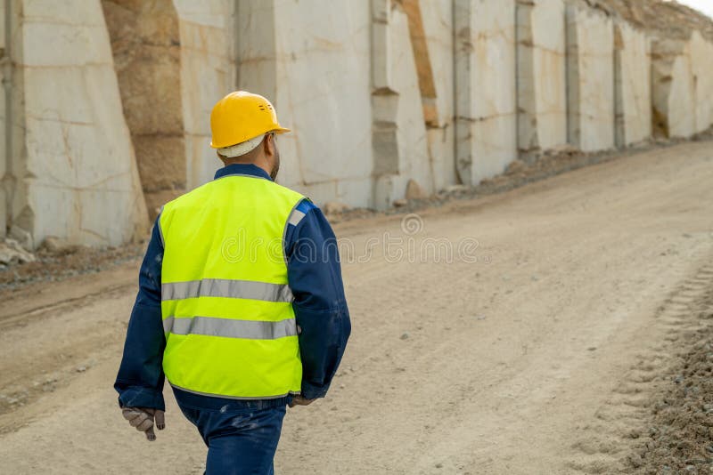 Back View of Young Builder in Workwear Moving Along Wall of Unfinished ...