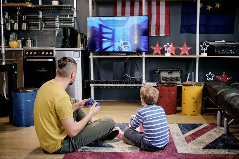 Back View of Young Man and Little Boy Playing Video Game Stock Photo ...