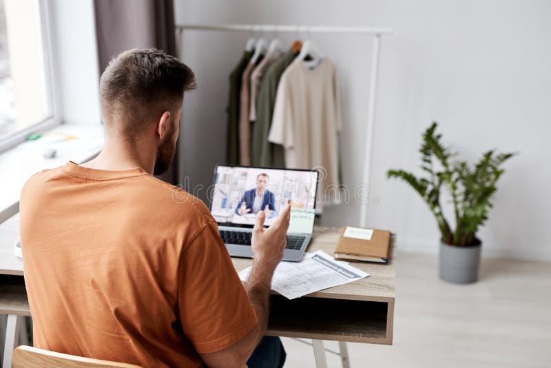 Back View of Young Man Sitting in Front of Laptop with Tutor on Screen ...