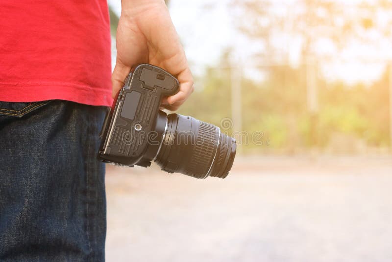 Back View of Young Photographer Holding Camera on Hands with Sunshine ...
