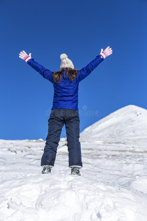 Back View of a Young Woman with Arms Raised Standing on the Top Stock ...
