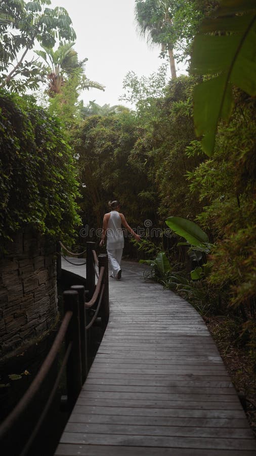 Back View of a Young Woman Strolling on a Lush Bali Resort Path Stock ...
