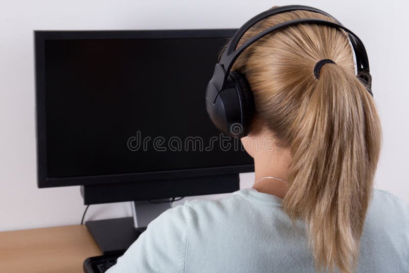 Back View of Young Woman Using a Computer and Listening Music Stock ...