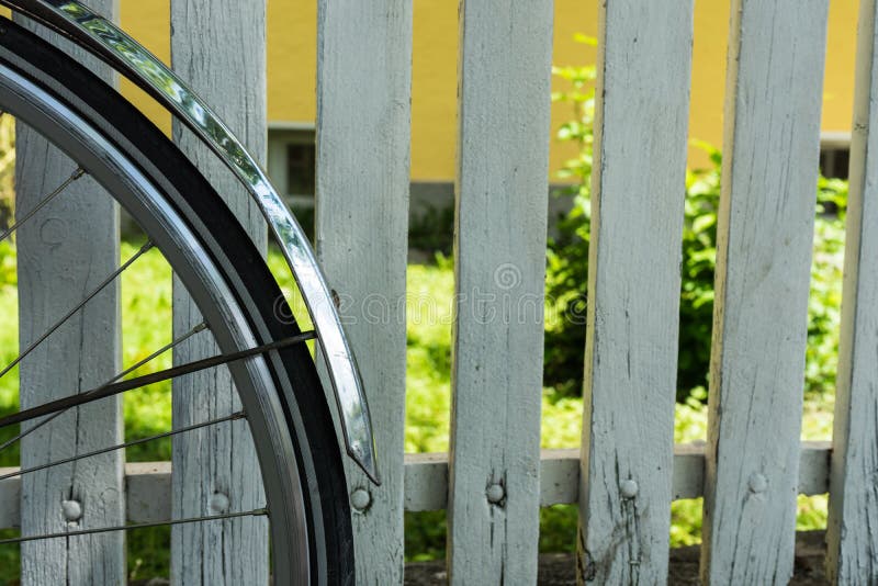 Back Wheel of Bicycle in Front of White Fence Stock Image - Image of ...