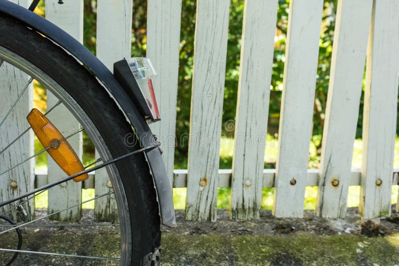 Back Wheel of Bicycle in Front of White Fence Stock Photo - Image of ...