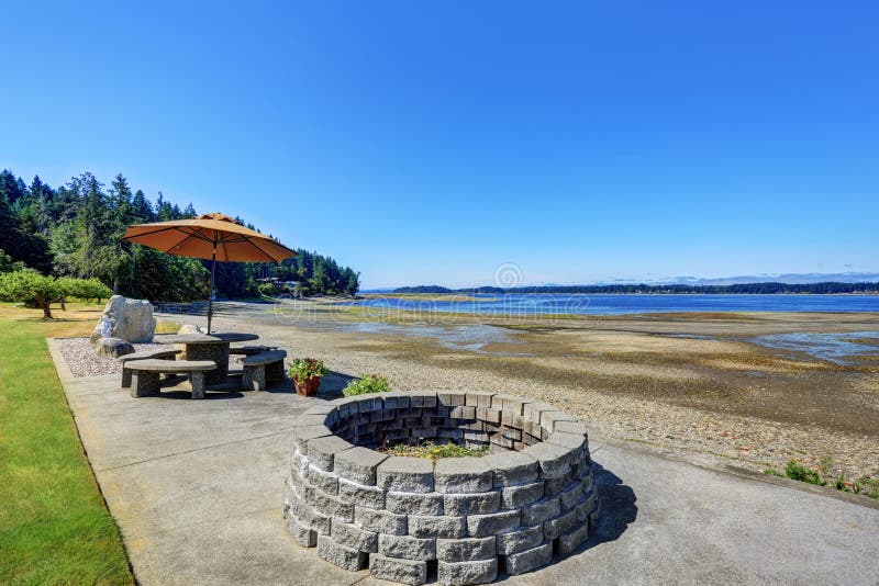 Back Yard with Stone Patio Table Set and Water View Stock Photo - Image ...