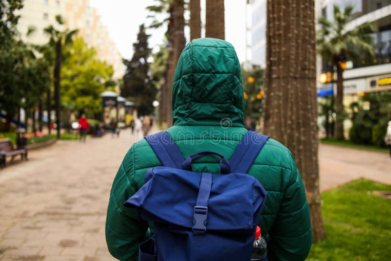 The Back of a Young Tourist with a Backpack on His Back Strolling ...