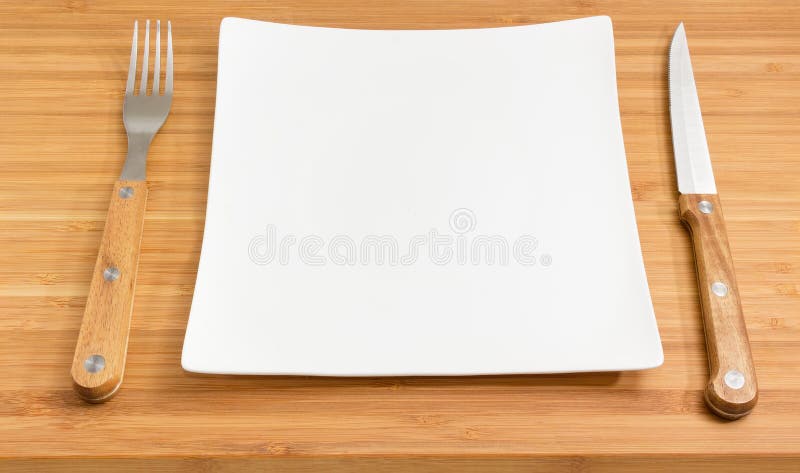 Empty Square White Dish, Fork and Knife with Wooden Handles Stock Image ...