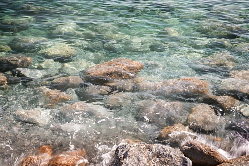 Background of Clear Waters Against a Rocky Beach Stock Photo - Image of ...