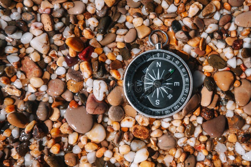 Background Image of Compass Lying on Small Pebbles of the Beach with ...