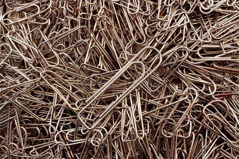 Background of Paper Clips in Steel Color. Staples are Scattered ...
