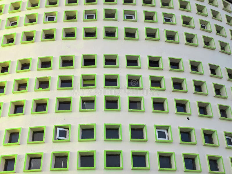 Wall with small square windows, painted in green, background texture ...