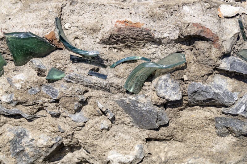 The Background is a Wall of Stone and Glass Embedded in the Concrete ...