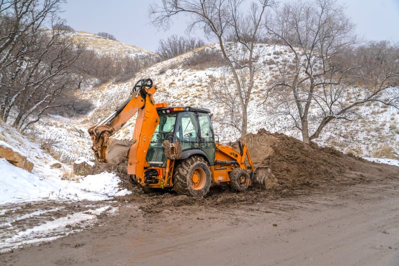 Backhoe Loader Against Snowy Hill and Trees Stock Image - Image of ...