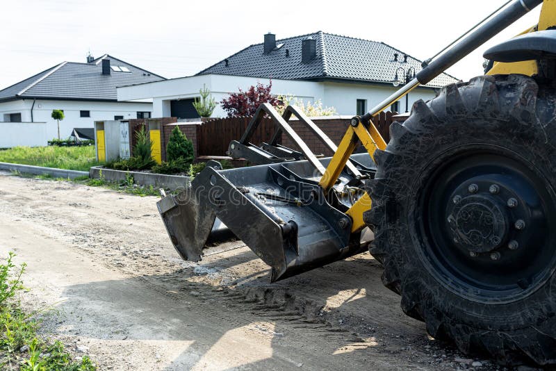 A Backhoe Loader Carries and Levels Rubble on a Dirt Road. Stock Photo ...
