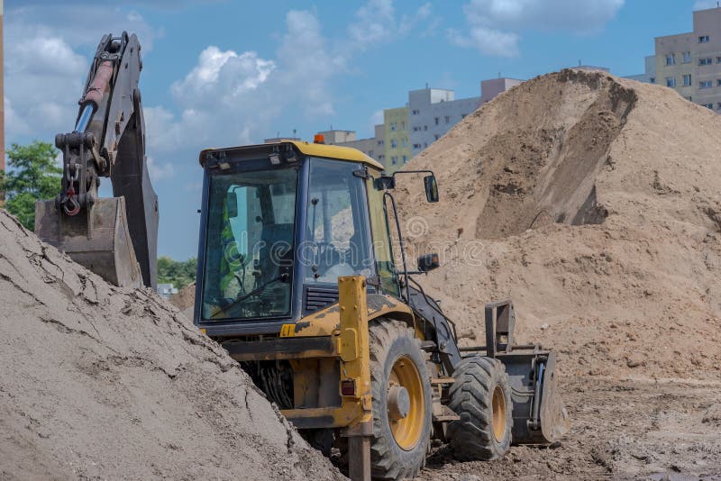 Backhoe Loader at a Construction Site among the "mountains". Stock ...