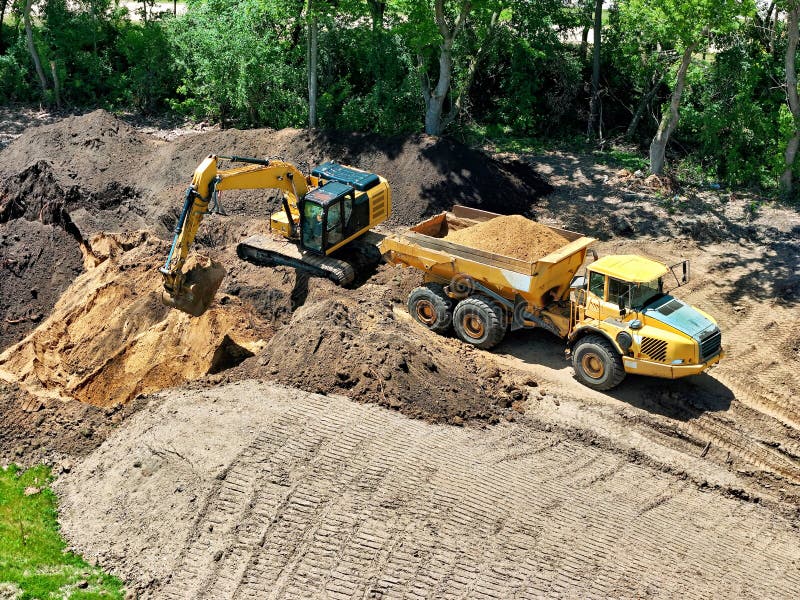 Backhoe Loading a Large Dump Truck at a Construction Site Stock Image ...