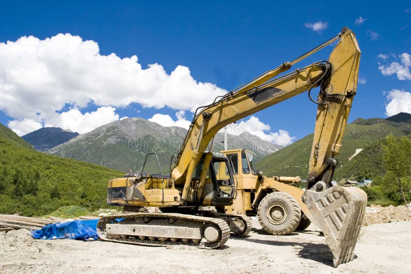 Backhoe Working Against a Mountain Landscape Stock Photo - Image of ...