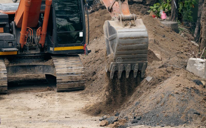 Backhoe Working by Digging Soil at Construction Site. Bucket Teeth of ...