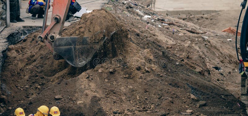 Backhoe Working by Digging Soil at Construction Site. Bucket Teeth of ...