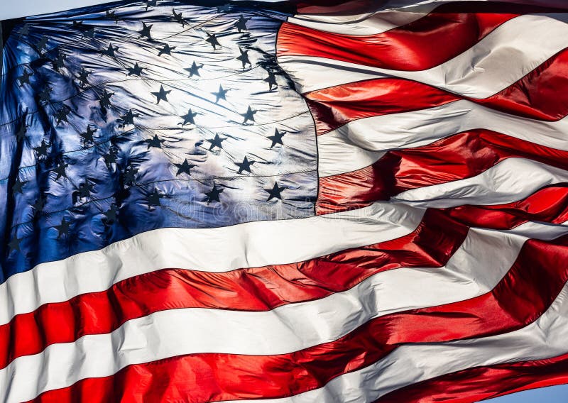 Backlit American Flag Waving in Wind Against a Deep Blue Sky Stock ...