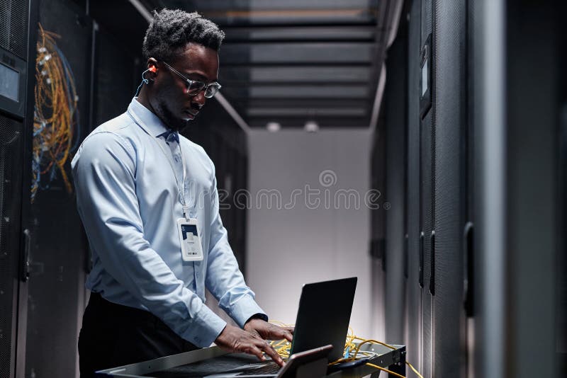 Backlit Data Engineer Using Laptop in Server Room Stock Photo - Image ...