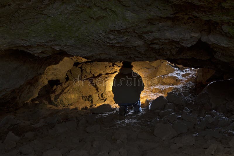 Backlit Man Exploring Dark Cave Stock Photo - Image of historic, tube ...