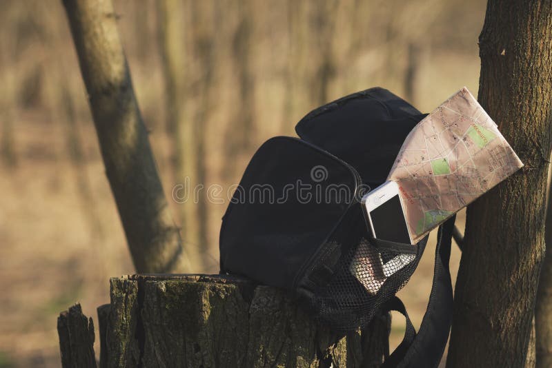 Backpack with Phone and Map in the Pocket on the Stump Stock Photo ...