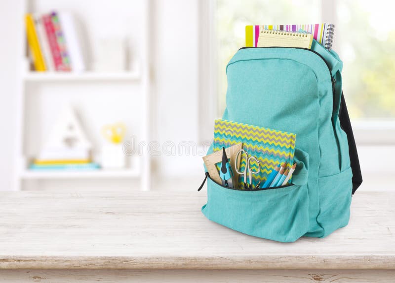 Backpack with School Supplies on Table Over Blurred Educational ...