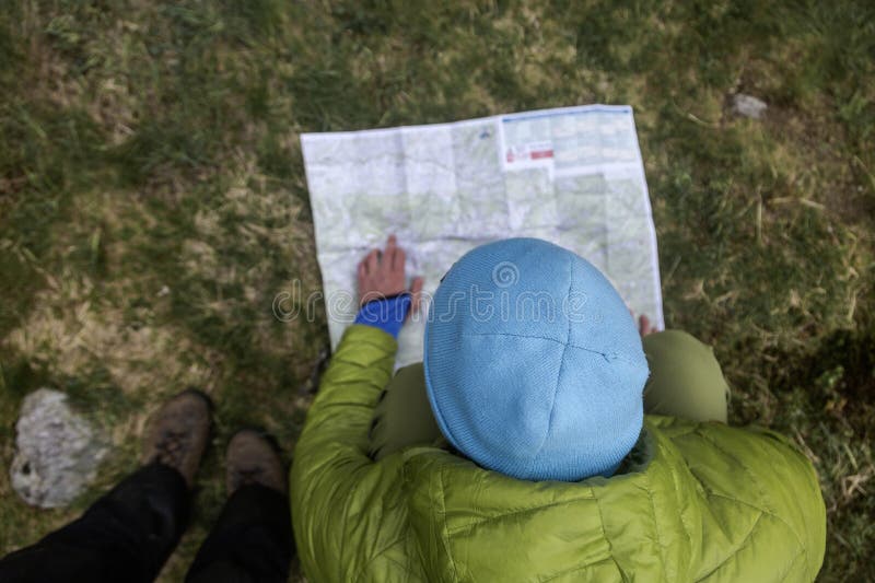 Backpacker Consulting Navigation Map in Natural Setting. Hiker Wearing ...