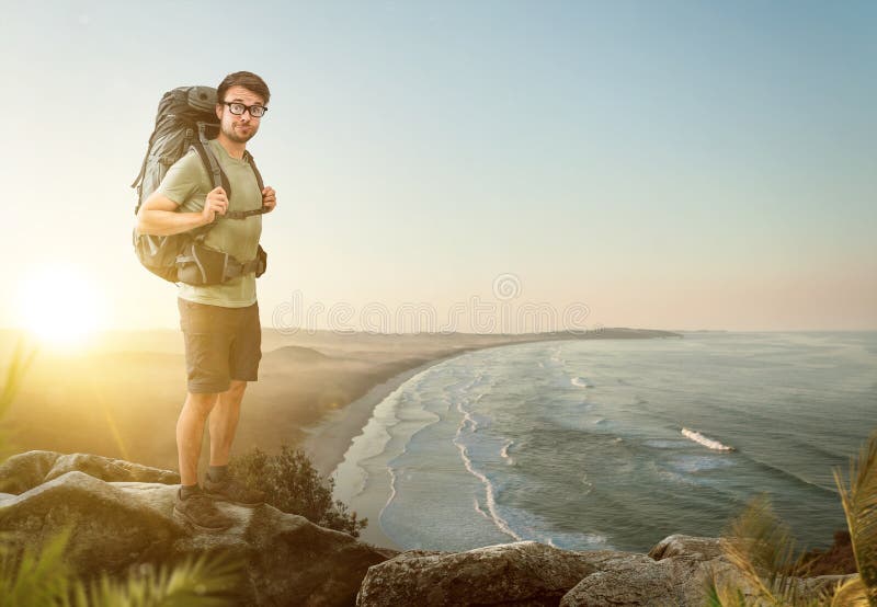 Backpacker Standing on a Hill Above a Beautiful Coastline at Sunset ...