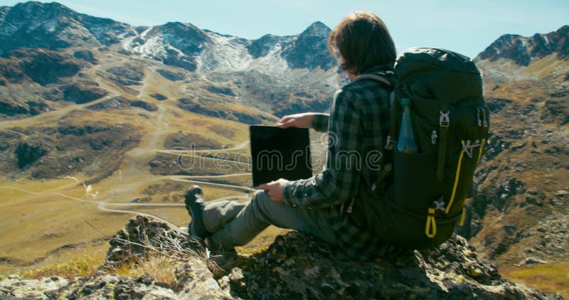 Backpacker Walk and Sit on Rock with Epic Mountain View and Open Laptop ...