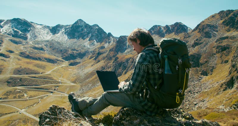 Backpacker Walk and Sit on Rock with Epic Mountain View and Open Laptop ...