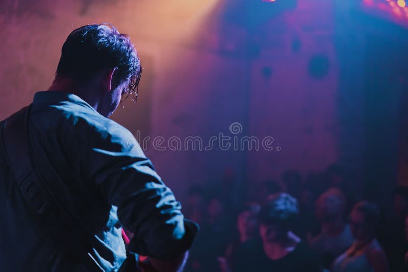 Backside View of a Musician Guy on the Stage Performing in Front of the ...