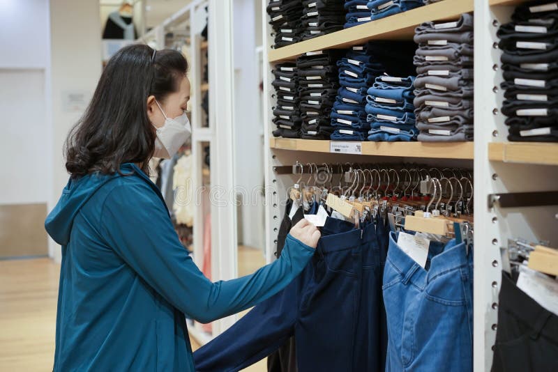 Backside of a Woman Wearing Face Mask Was Selecting Navy Pants on a ... Backside of a Woman Wearing Face Mask Was Selecting Navy Pants on a ...