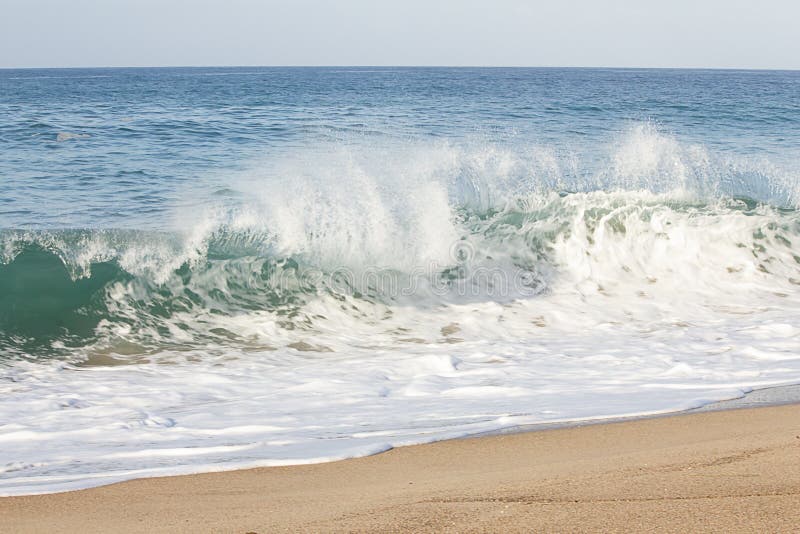 Backspray Cresting Wave with Backwash Foam Breaking on a Sandy ...