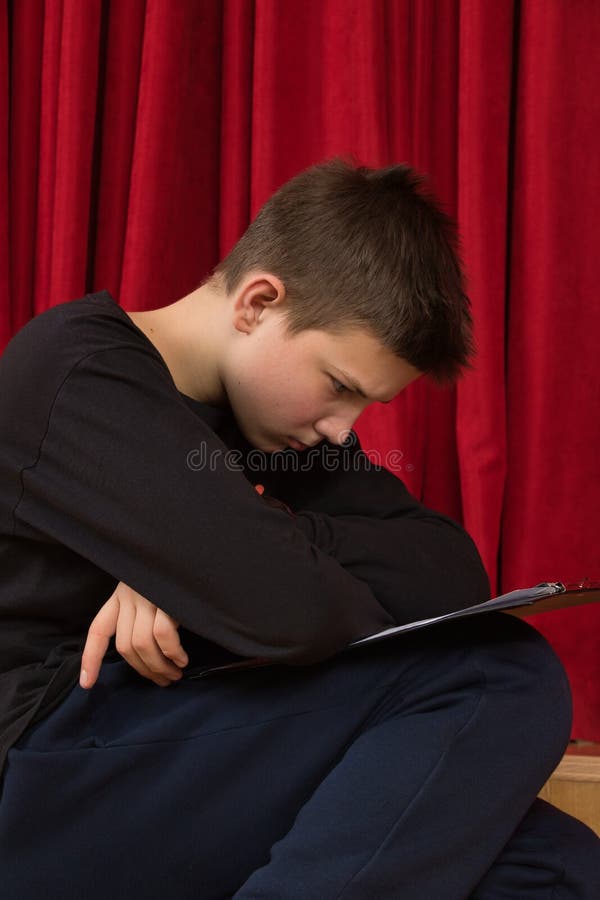 Backstage at the Stage, a Young Actor is Carefully Studying His Script ...