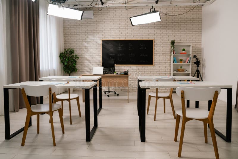 A Modern Classroom with Green Walls, Red Chairs, White Tables, and ...
