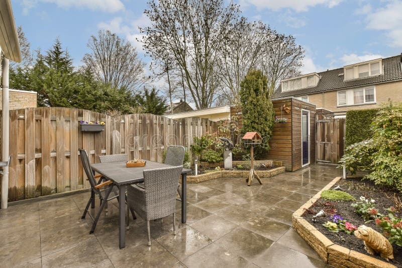 A Backyard with a Table and Chairs and a Fence Stock Image - Image of ...