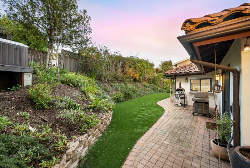 Backyard Featuring a Charming Patio with a BBQ Grill and Verdant Lawn ...