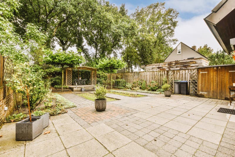 The Backyard Has a Tiled Patio and a Garden Stock Image - Image of ...